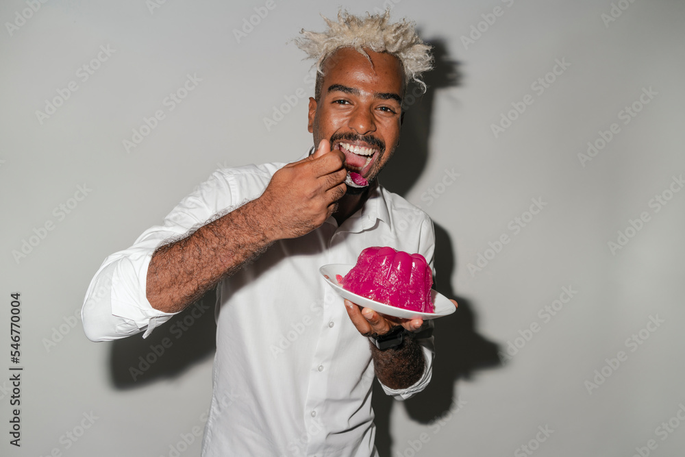 Excited young Middle Eastern man eating jelly Stock Photo | Adobe Stock