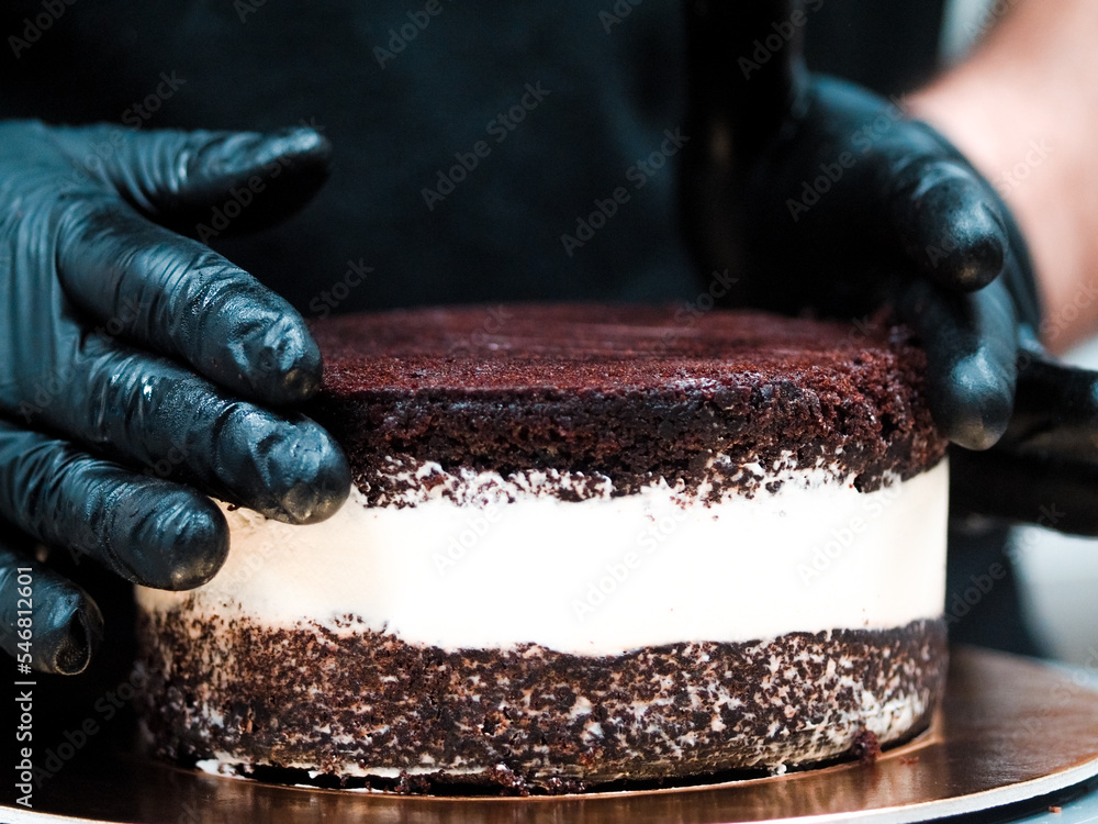 Chef cake designer preparing layered creamy butter cream blank cake for ...