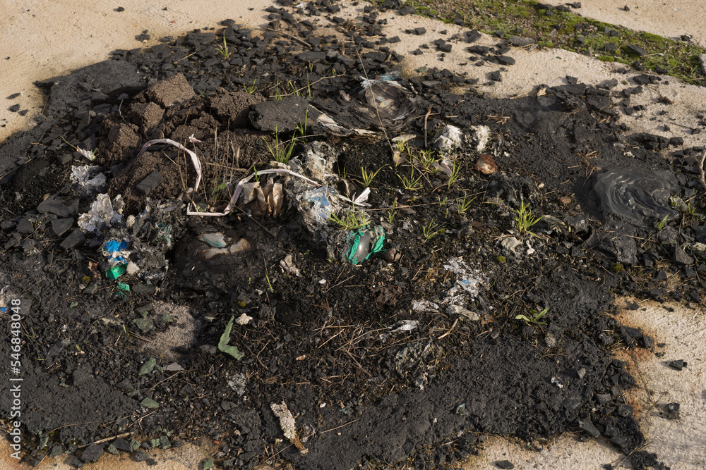 Concept vandalism remains of a burnt garbage can melted plastic and ...