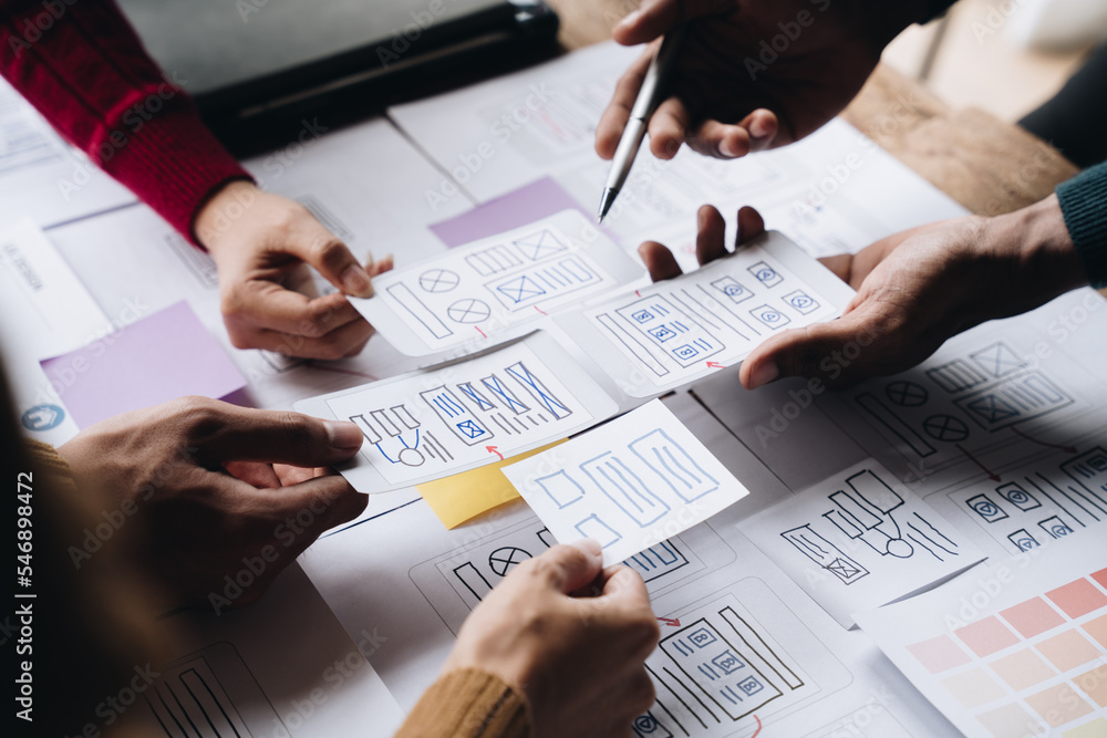 Young Asian business creative team work together, mobile application software design project ...