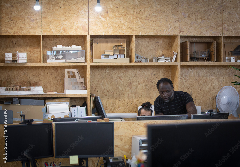 Businessmen working at computer in open plan office Stock Photo | Adobe ...