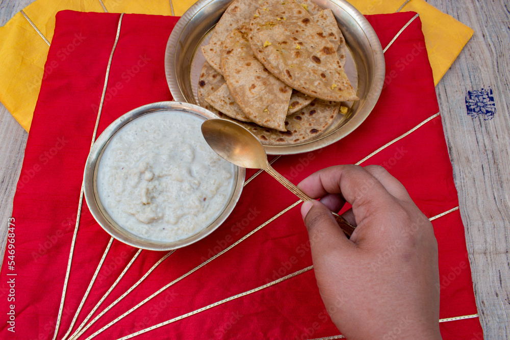 Dal Puri or dal stuffed paratha in brass plate and Gur kheer or kheer ...