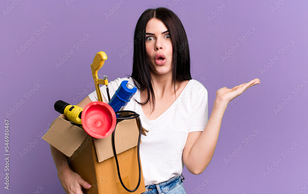 looking surprised and shocked, with jaw dropped holding an object ...