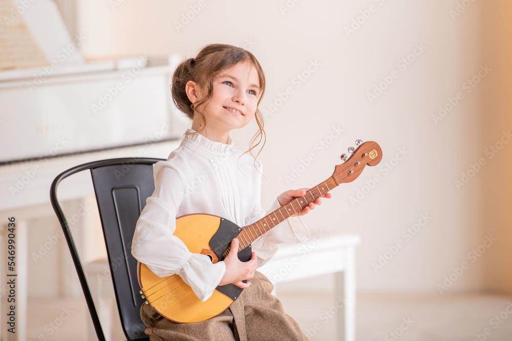 A teenage girl a young musician plays a stringed musical instrument ...
