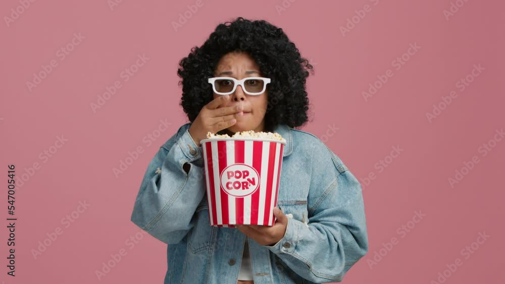 Woman hugging a bucket with popcorn, scared hiding face behind black ...