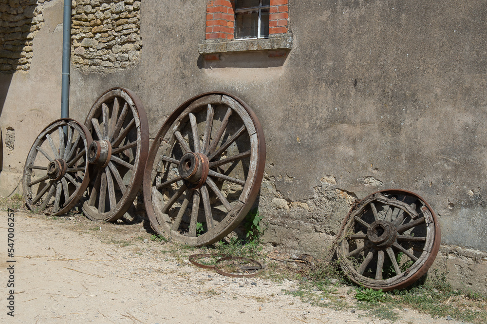 Four old wooden wheels with metal strapping, designed for hay and straw ...