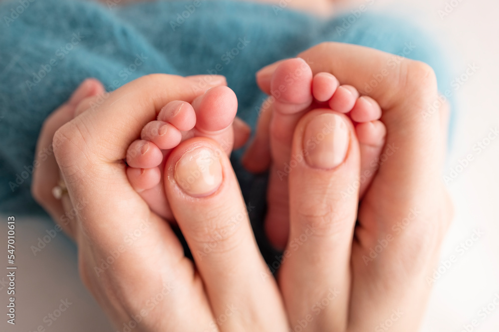 Mother is doing massage on her baby foot. Close up baby feet in mother ...
