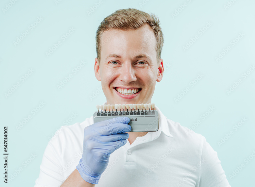 Young man smiling with natural white teeth in light blue background in ...