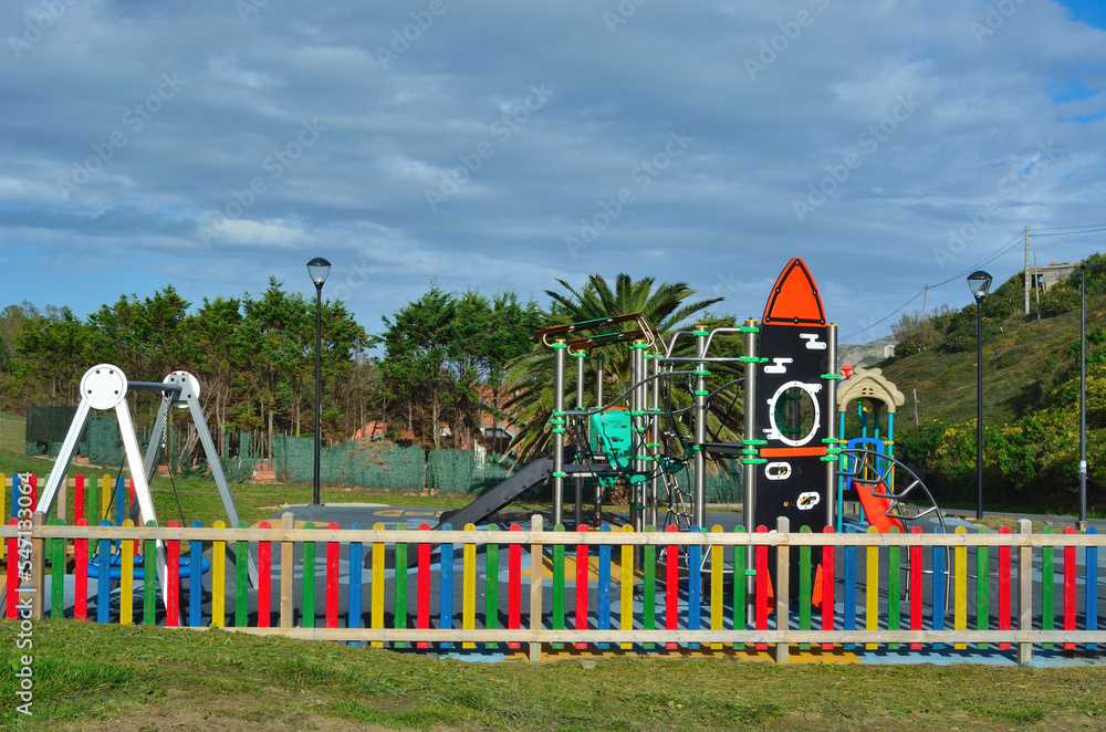 Parque infantil colorido sin niños rodeados de arboles y cesped con ...