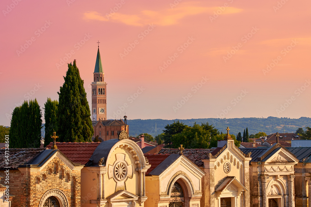Blick über einen Friedhof in Pieve di Soligo im letzen Abendlicht . Im ...