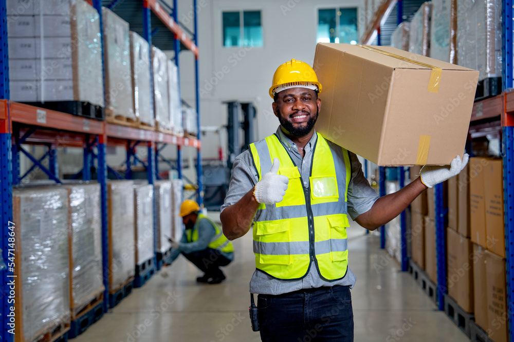 African American warehouse worker carry the box on his shoulder and ...