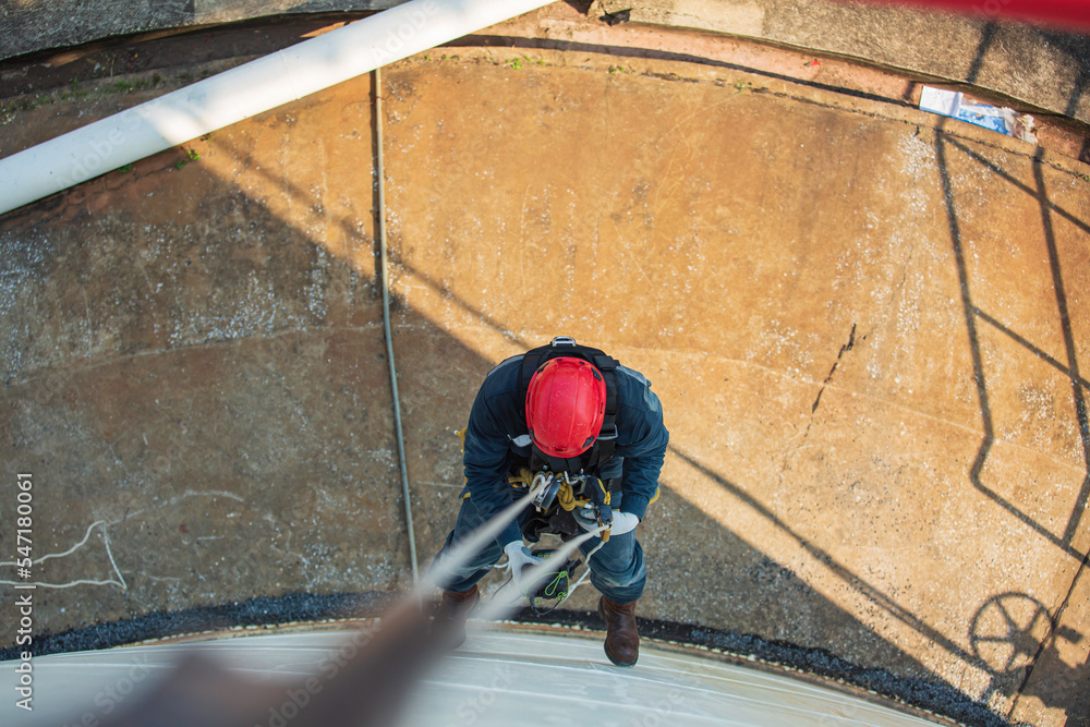 Top view pic of industrial rope access welder working at height wearing ...