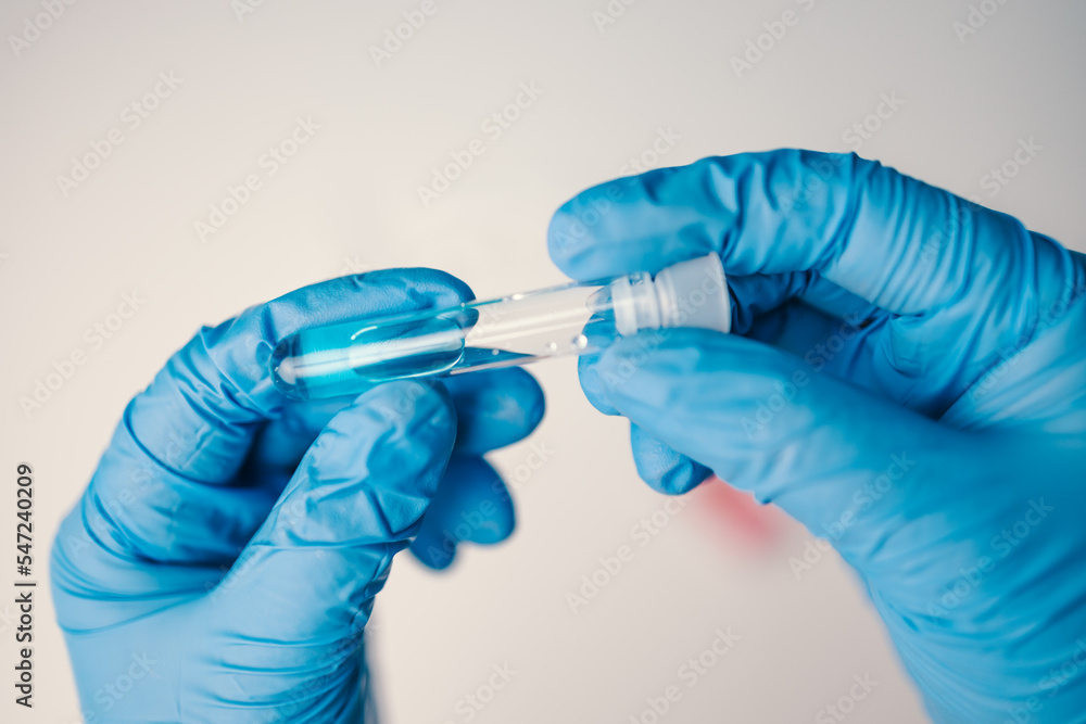 A laboratory employee taking sample PCR microtubes with cotton swab ...