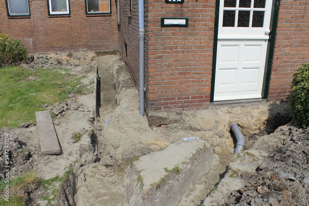deep trenches with pipes and drainage in the garden next to the house ...