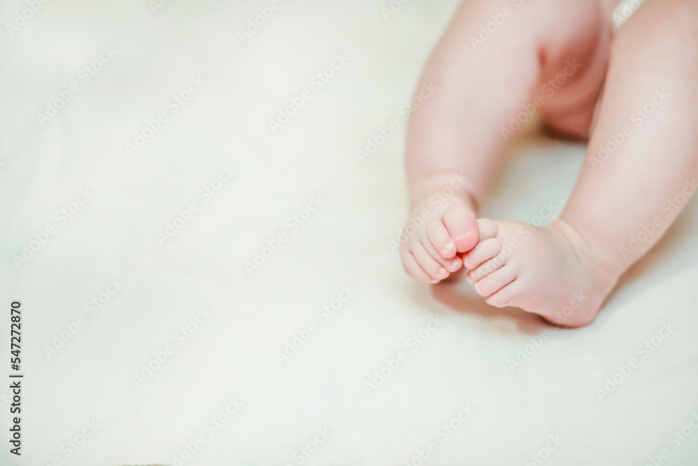 The legs of the baby 2-5 months folded her fingers together. tiny legs ...