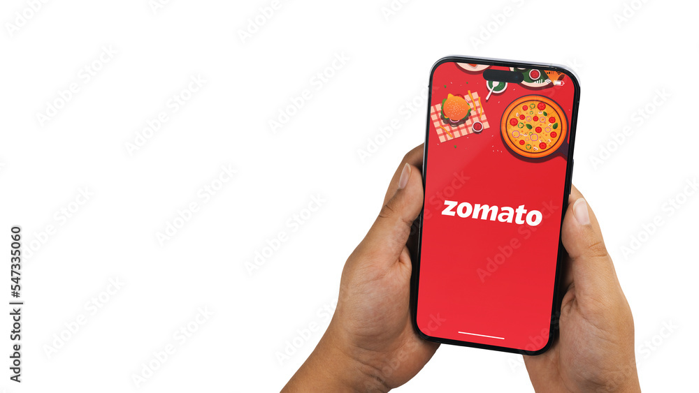 Boy holding a smartphone iPhone 14 Pro with Zomato delivery app on the ...