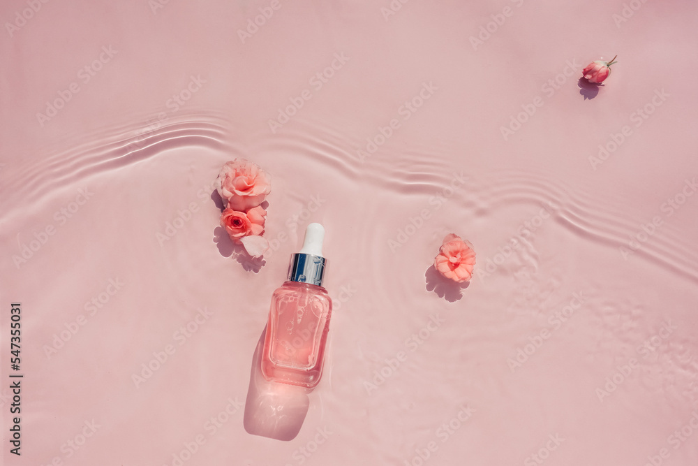 Pink bottle with transparent serum, collagen, pink water background ...