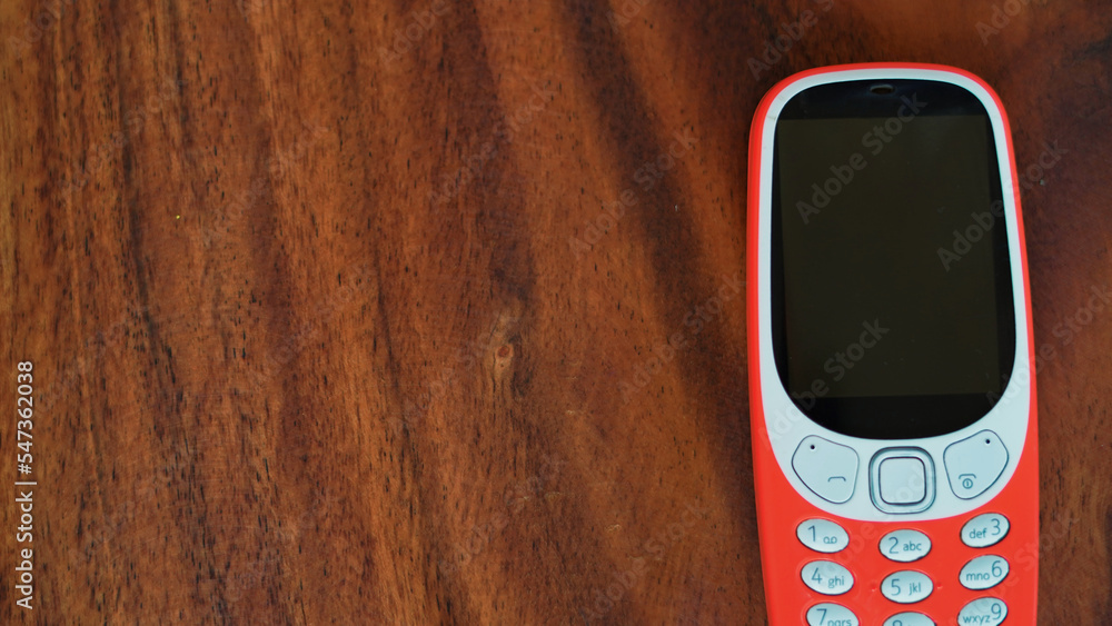A keypad phone with buttons isolated on black background. Old Cell ...