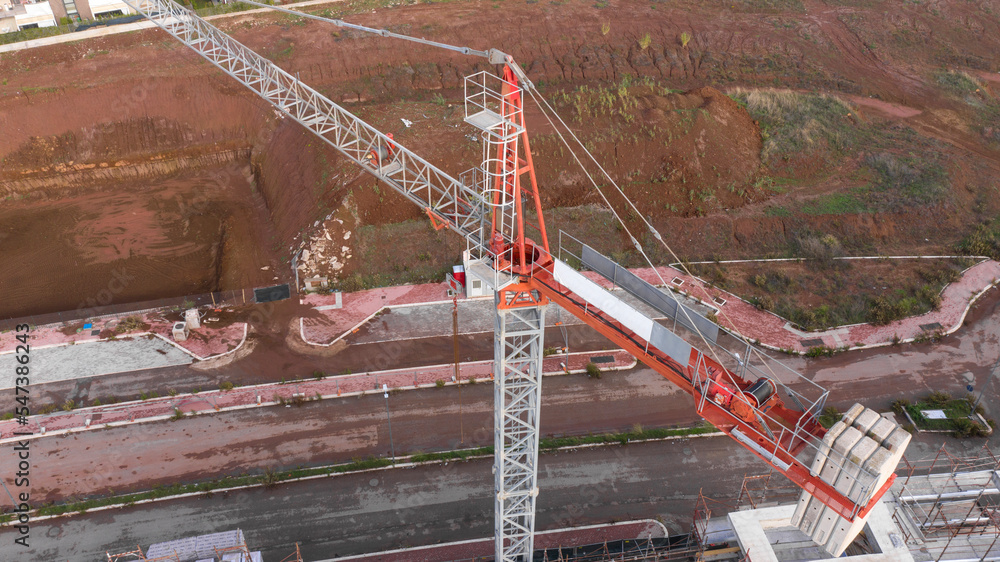 Aerial view of a industrial tower crane operating in high building ...