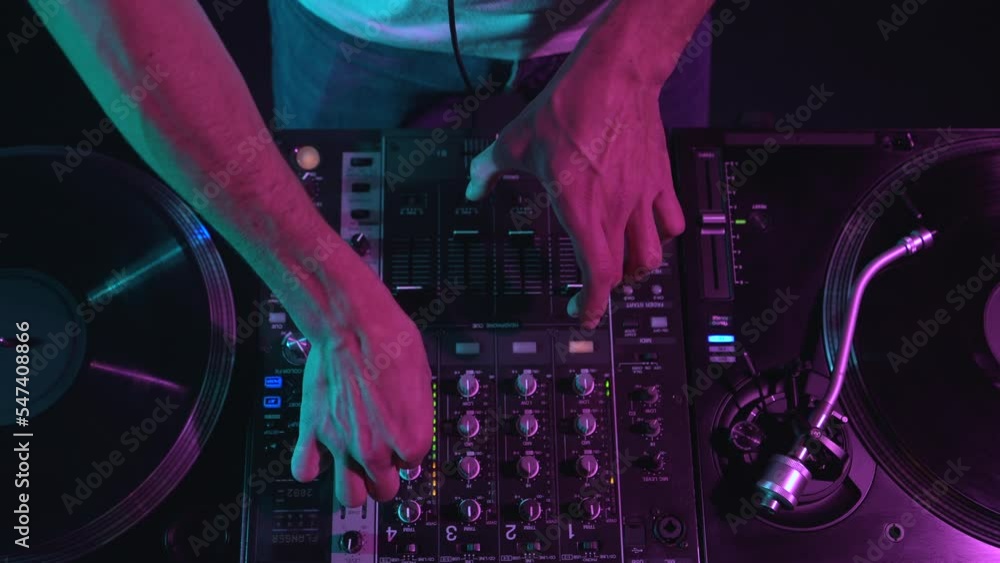 Overhead video clip of club DJ mixing musical tracks on a party ...