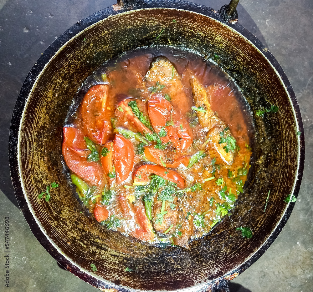 Bengali fish curry in pan. This is popularly known as Chital macher ...