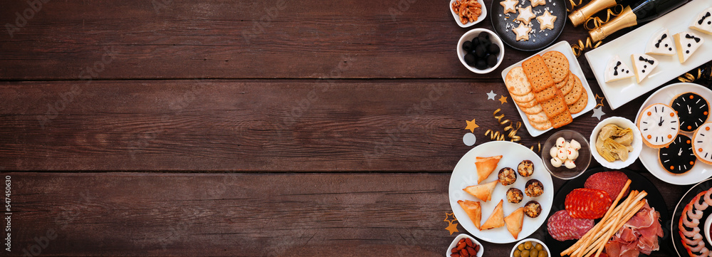 New Years Eve theme appetizer side border. Top down view on a dark wood ...