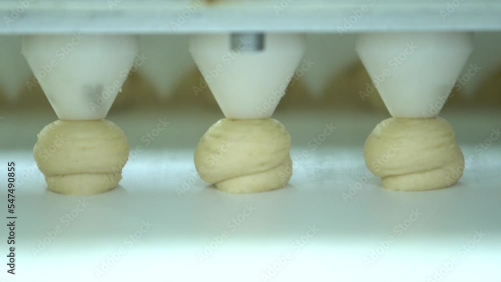 Sweet pastry dough passes through the mechanism and goes to cooking on ...