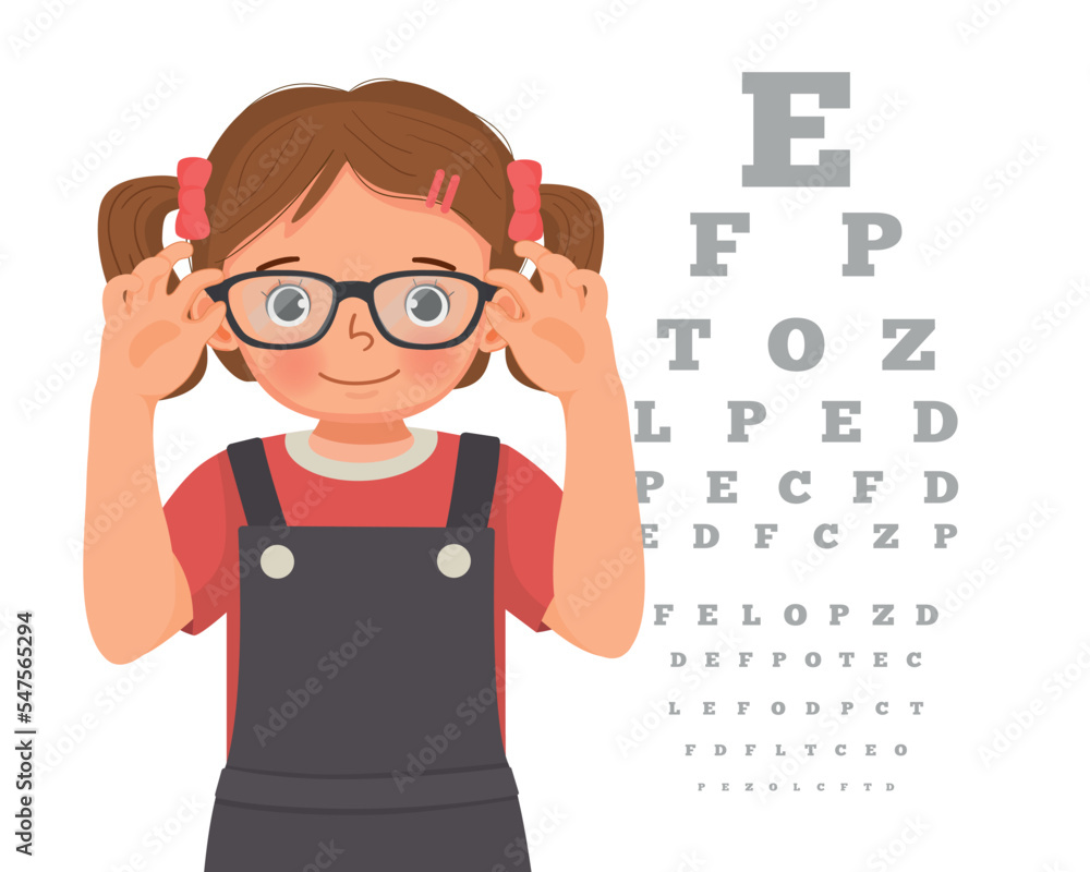 Cute little girl testing her new eyeglasses reading block letters at ...