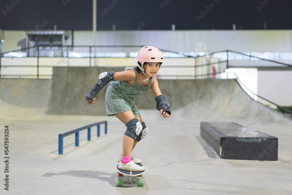asian child skater or kid girl fun riding skateboard or surf skate with ...