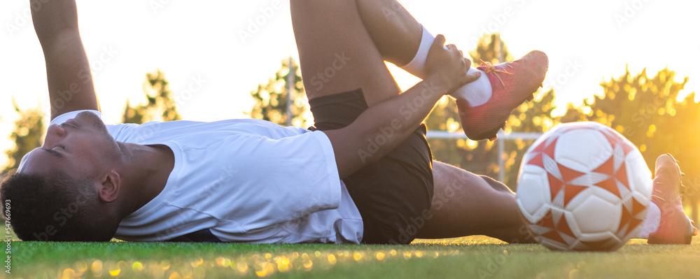 Football player with leg pain on the field. Football player lying on ...