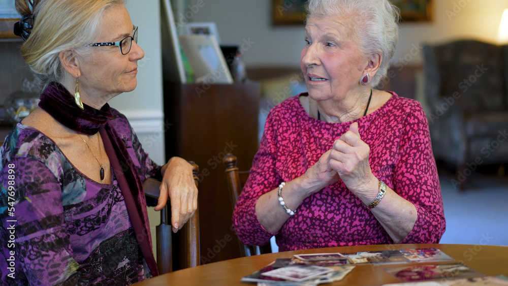 Senior elderly smiling woman looking at old photos and remembering ...