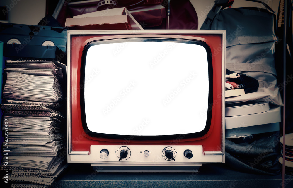 An old CRT TV set inside a dark storage room, with VHS tapes and paper ...