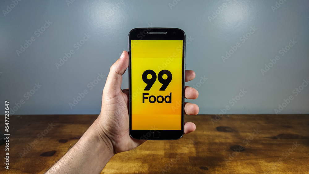 Delivery 99 food. Smartphone with 99 food logo on it. 99 food is a ...