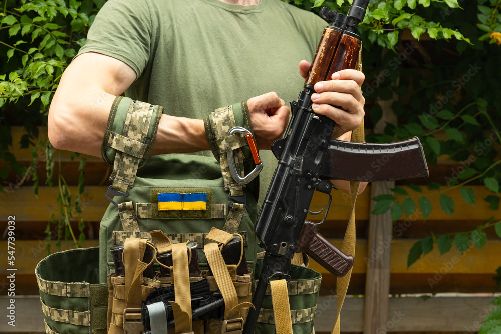 A military man in a military body armor with a tactical Kalashnikov ...
