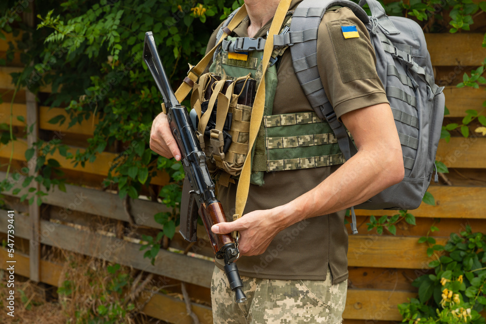 A military man in a military body armor with a tactical Kalashnikov ...