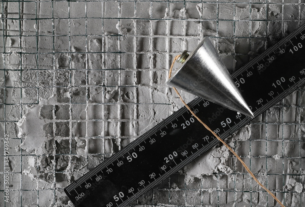 Wet cement reinforcement with wire mesh, metal engineer corner ruler ...
