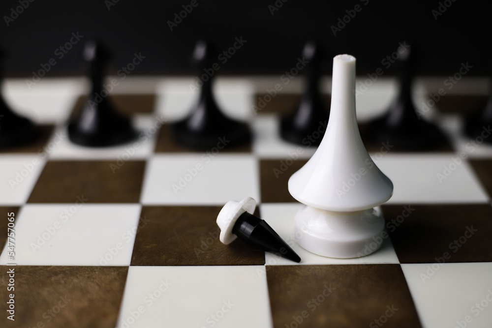 on a game sports chess board there is a chess piece of a white defeated ...