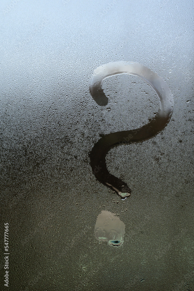 Fogged glass, a question mark is written on the window with ...