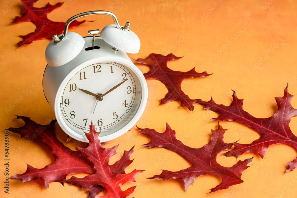 Classic white analog alarm clock on a textured orange background, happy ...
