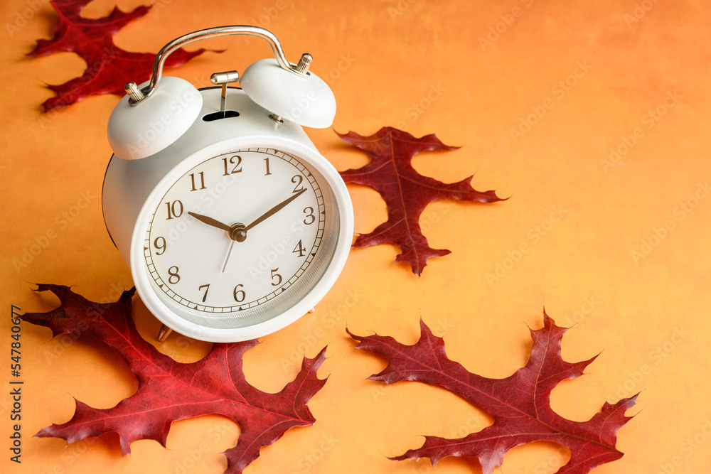 Classic white analog alarm clock on a textured orange background, happy ...