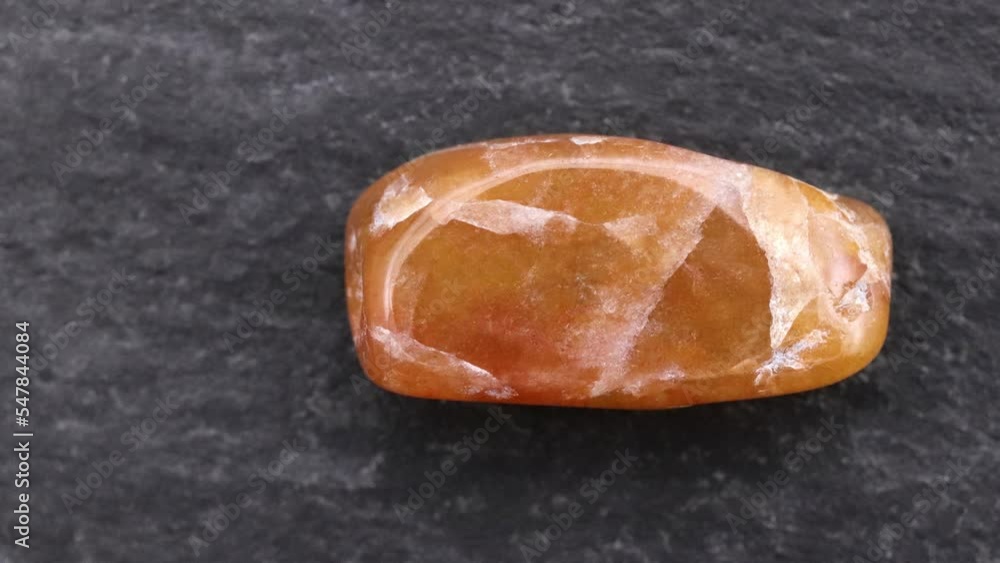 Red silk jade jewel stone texture on black stone background. Macro ...