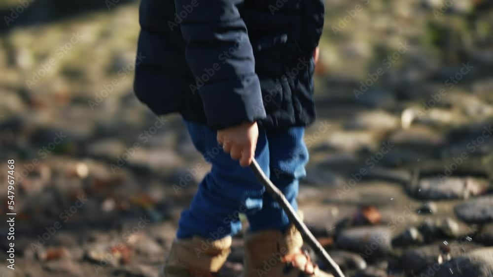 Child playing with stick outside in nature. Little boy exploring the ...