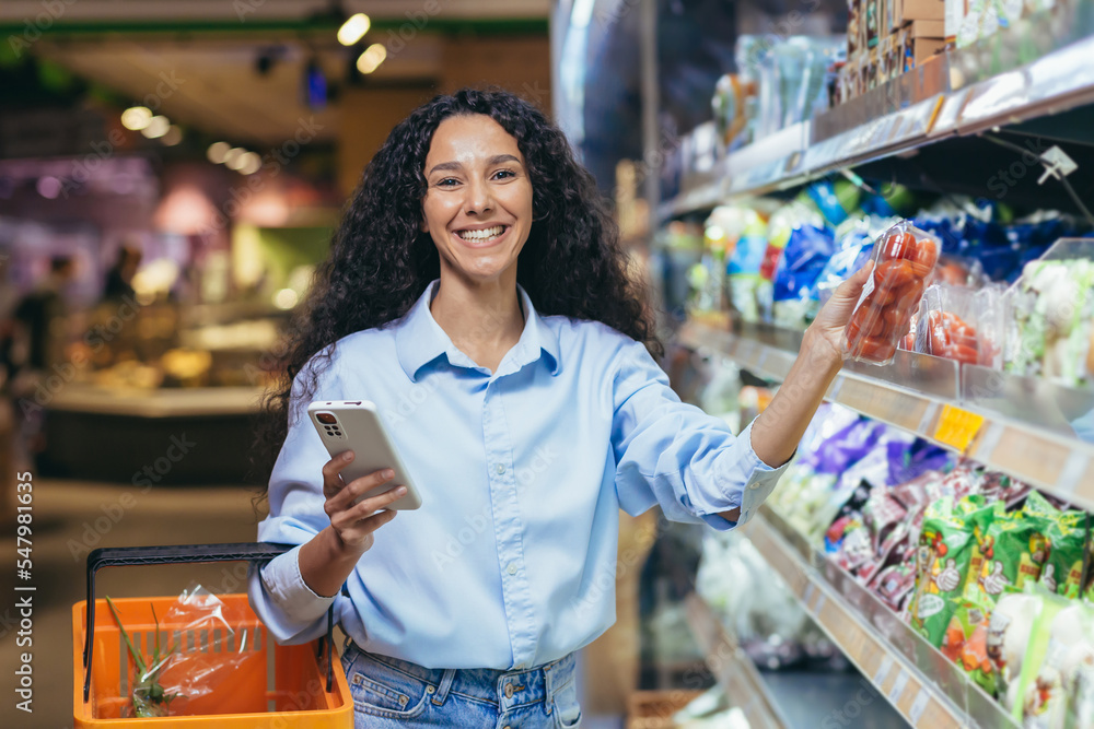 Portrait happy and smiling woman shopper in a supermarket Hispanic ...