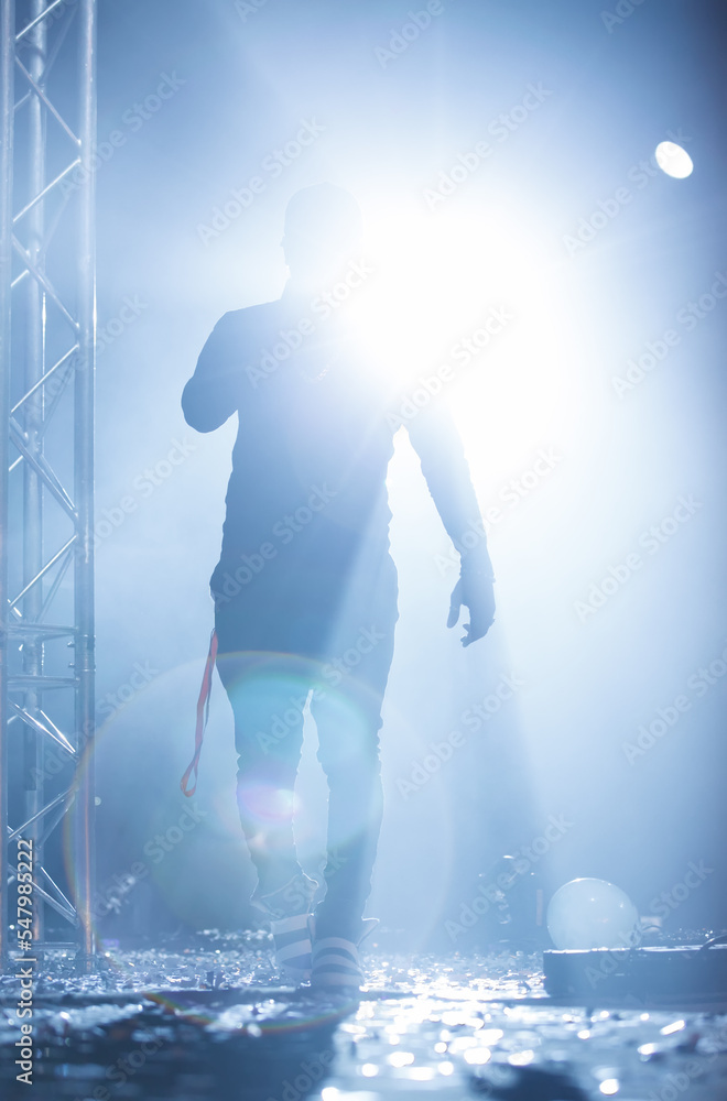Silhouette of rap singer performing on scene. Rapper with mic in hand ...