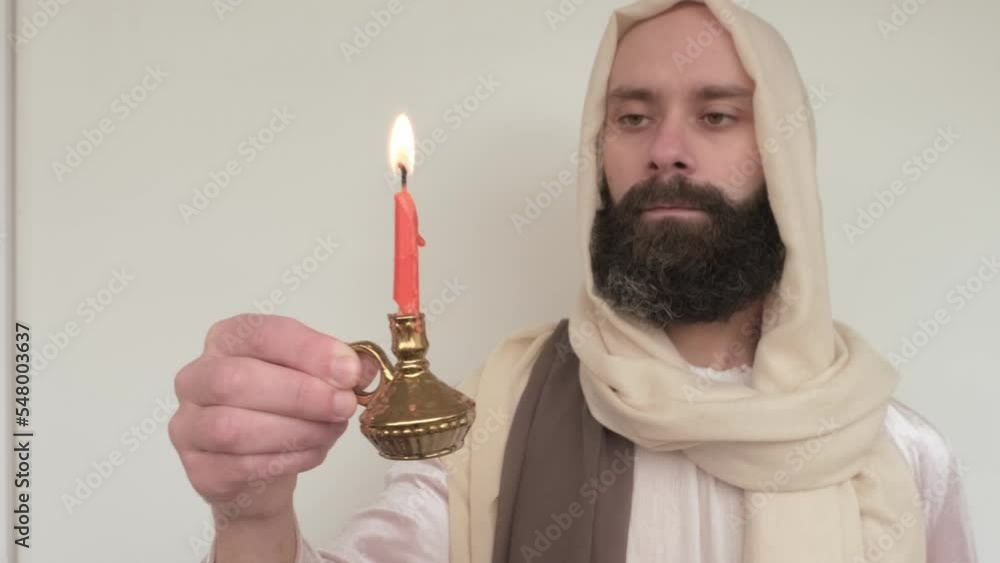 biblical scene, Jesus Christ Hand holds burning candle, young bearded ...