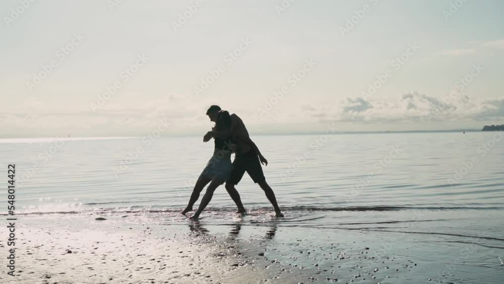 Couple conflict on beach, violent man attacking woman, silhouettes view ...