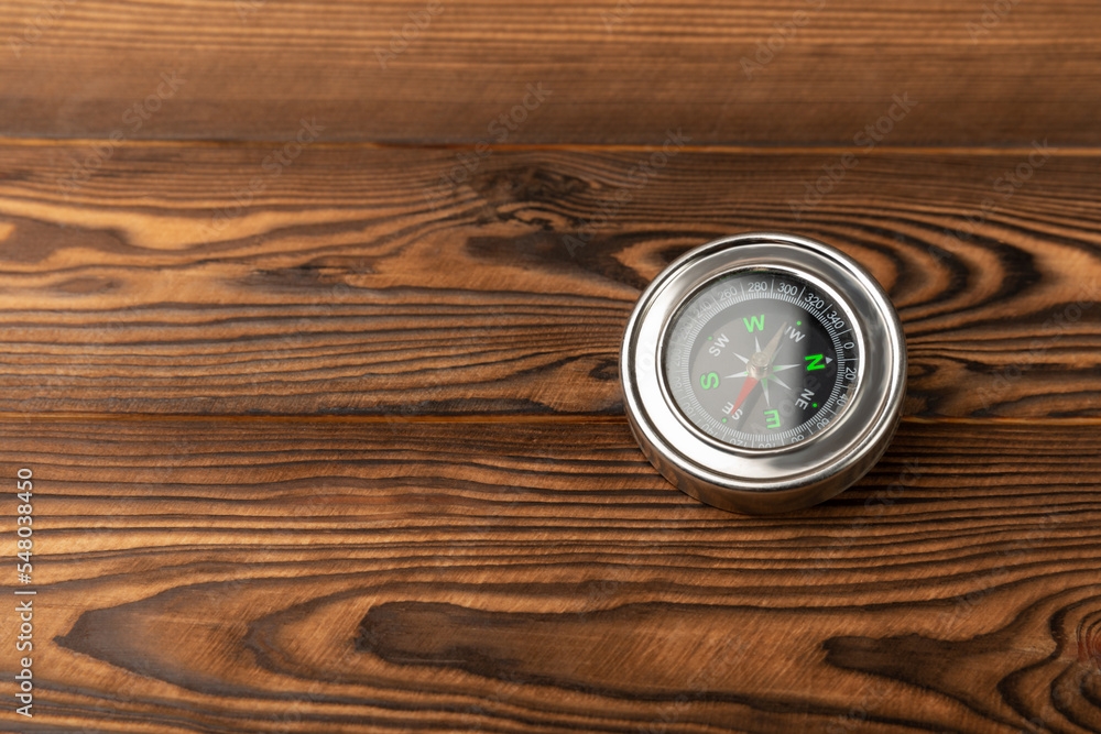 Classic round compass on a brown textured background. Symbol of tourism ...