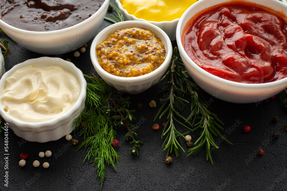 Different types of sauces in bowls with seasonings, rosemary and dill ...