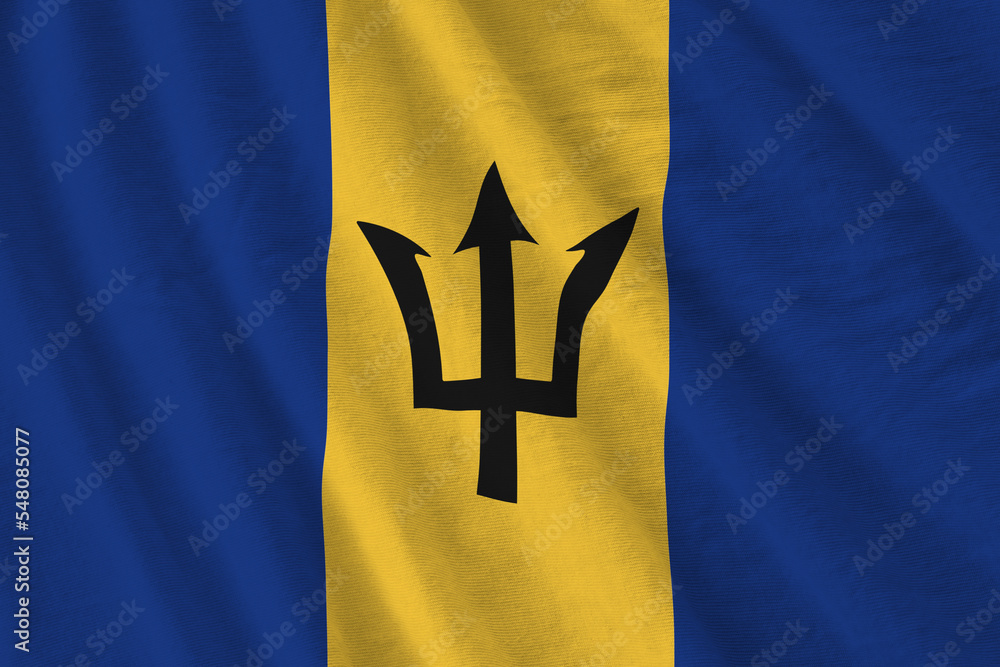 Barbados flag with big folds waving close up under the studio light ...