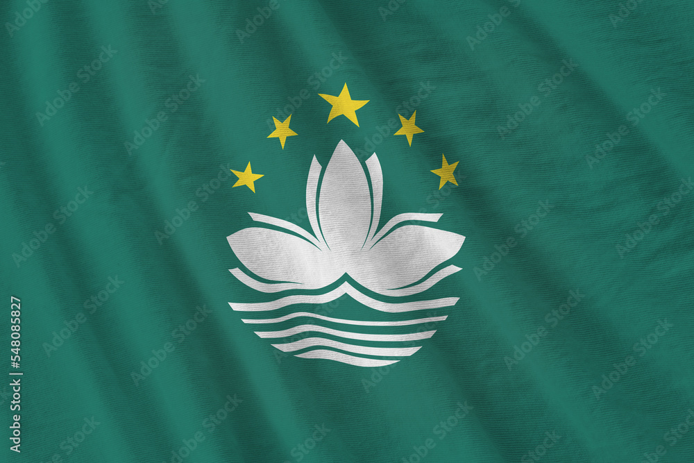 Macau flag with big folds waving close up under the studio light ...